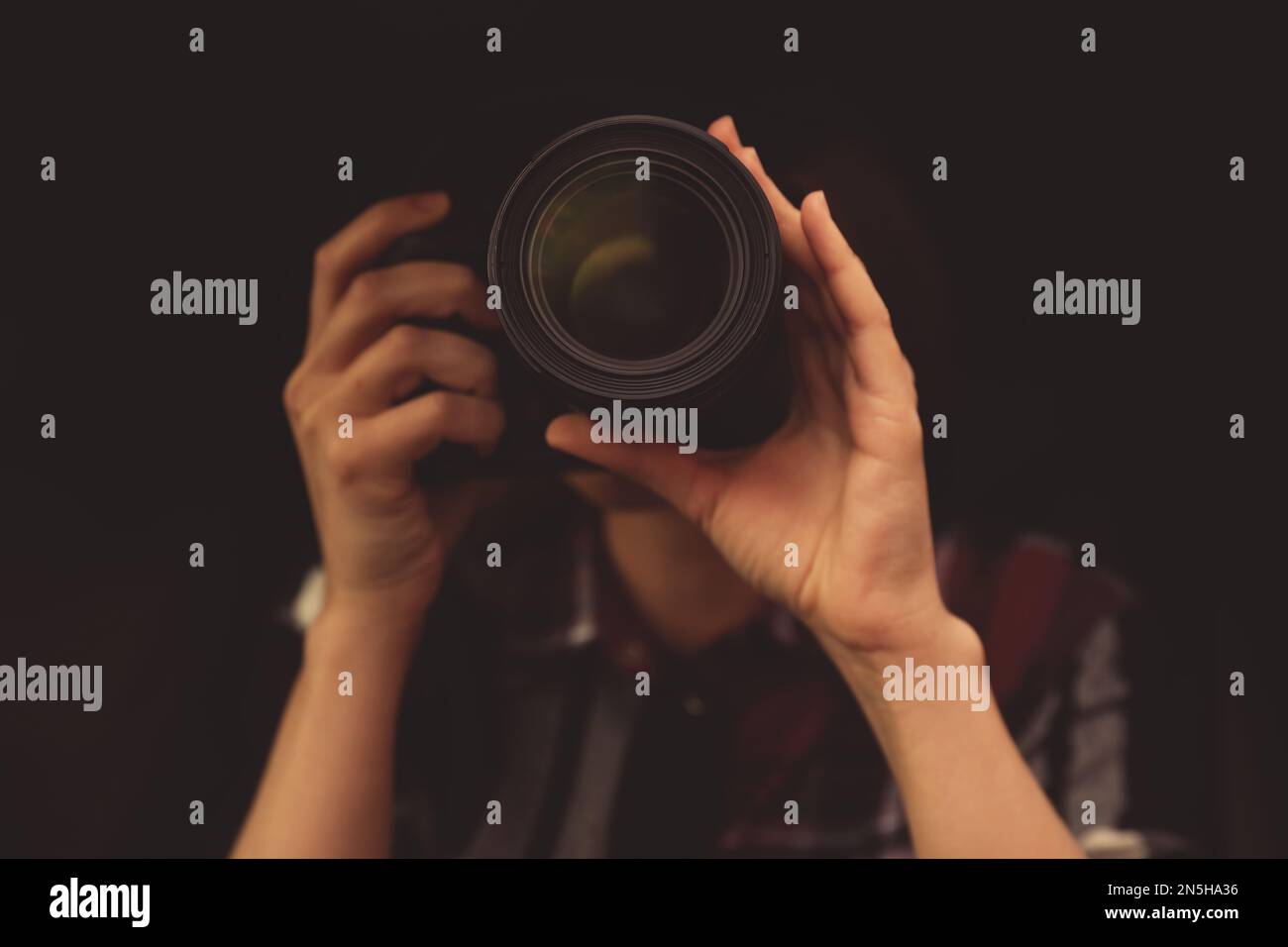 Private detective with camera spying against black background, focus on ...