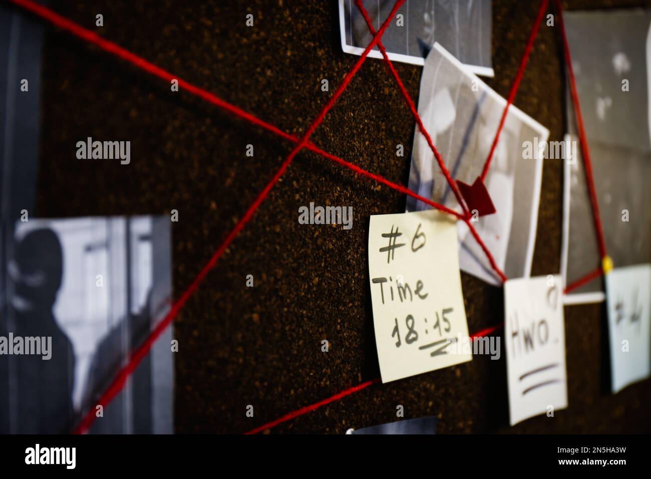 Detective board with crime scene photos, stickers, clues and red thread ...