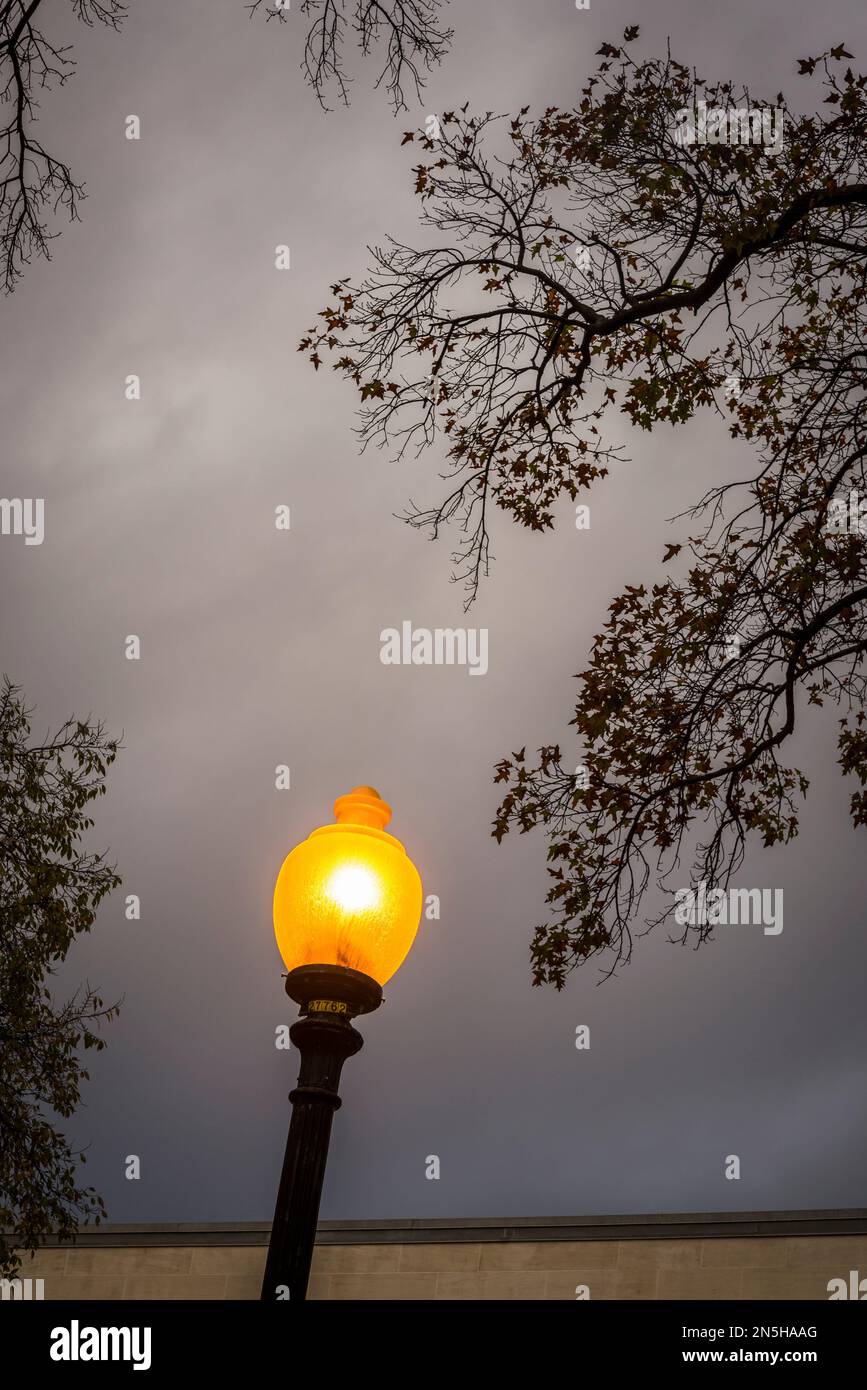Lit street lamp against moody twilight sky Stock Photo - Alamy