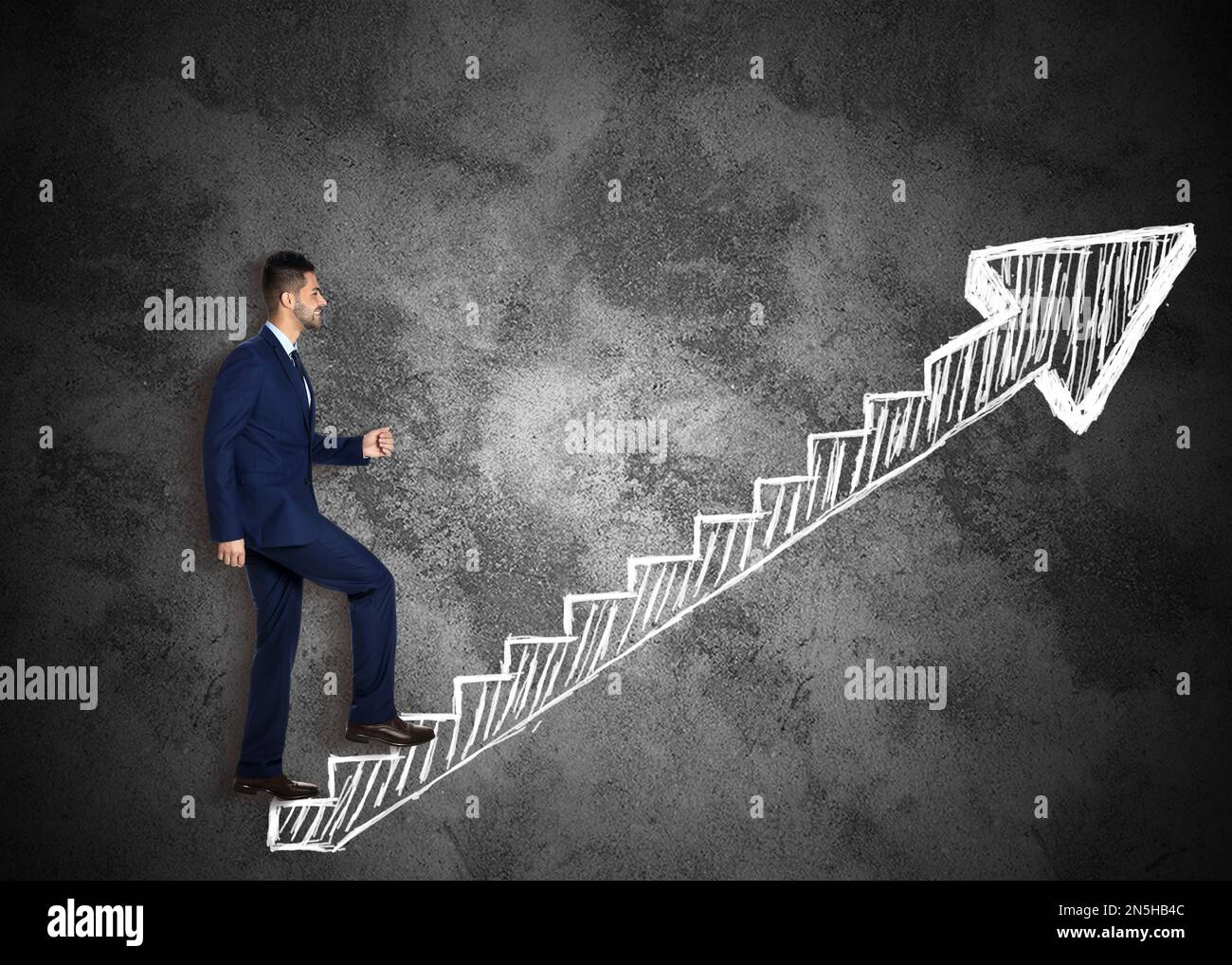 Businessman walking up stairs drawing with chalk on dark background ...