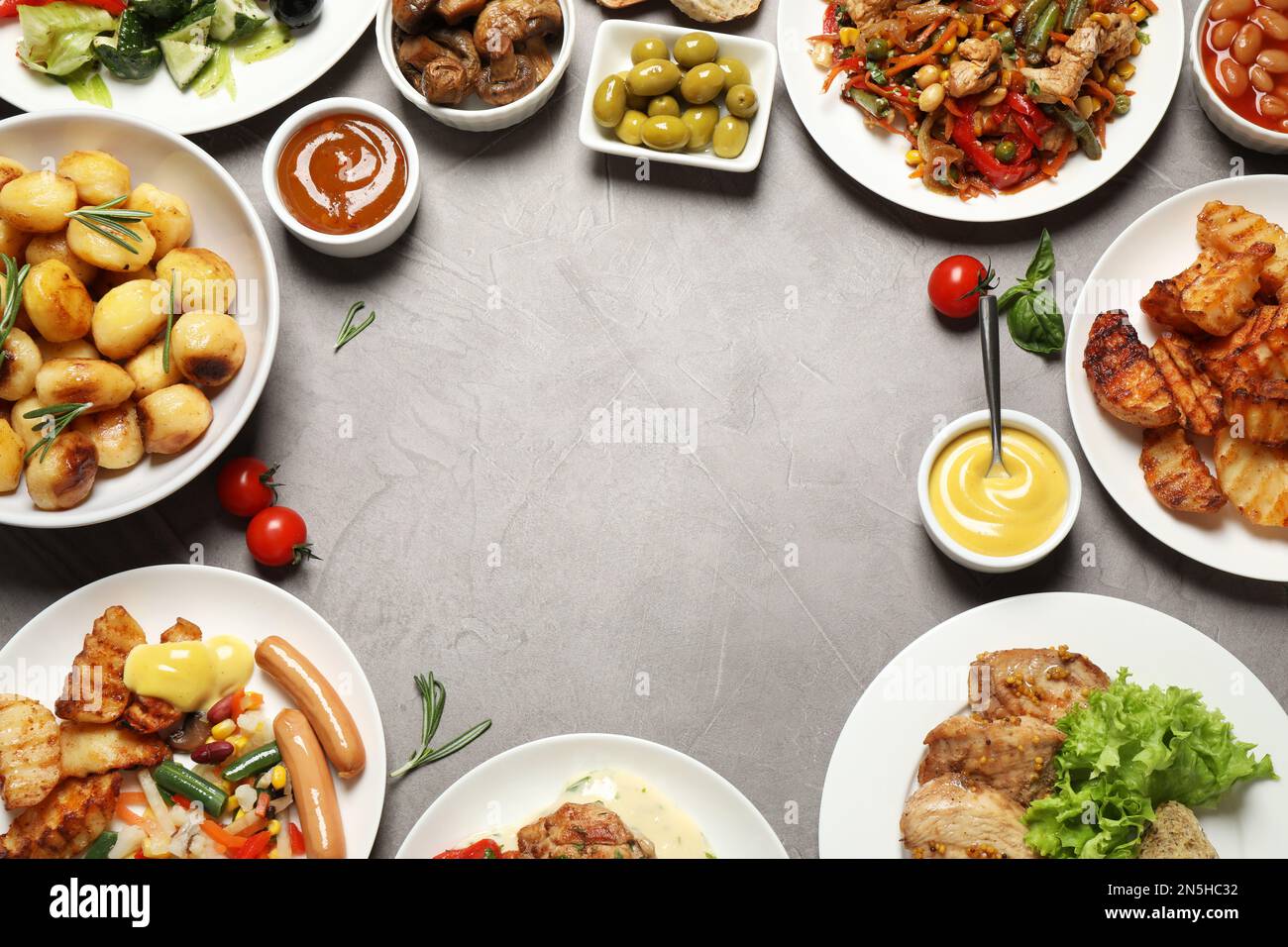 Buffet service. Frame of different dishes on grey table, space for text ...