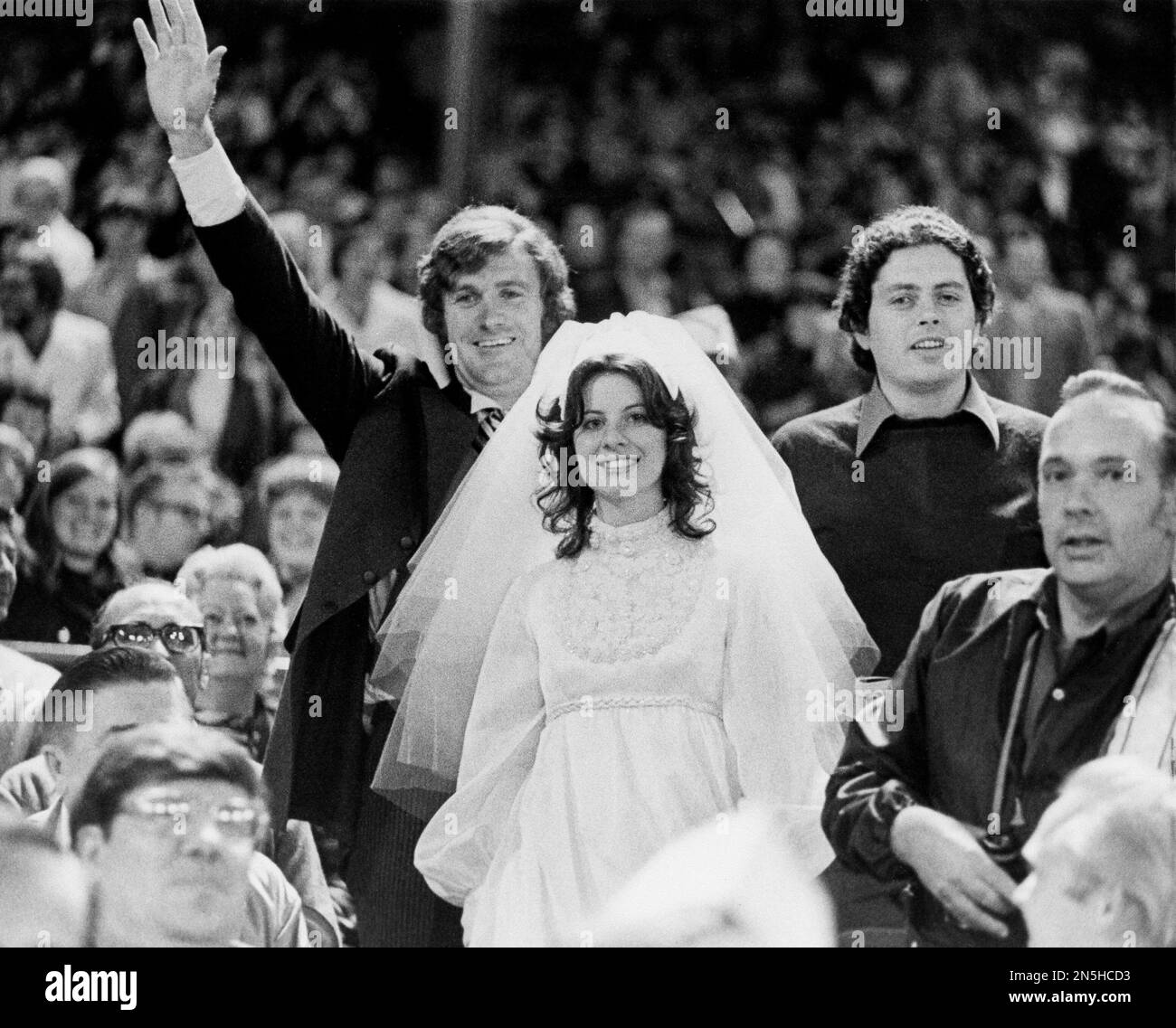 Mr. and Mrs. Timothy White of Milwaukee wave to friends as they arrive ...