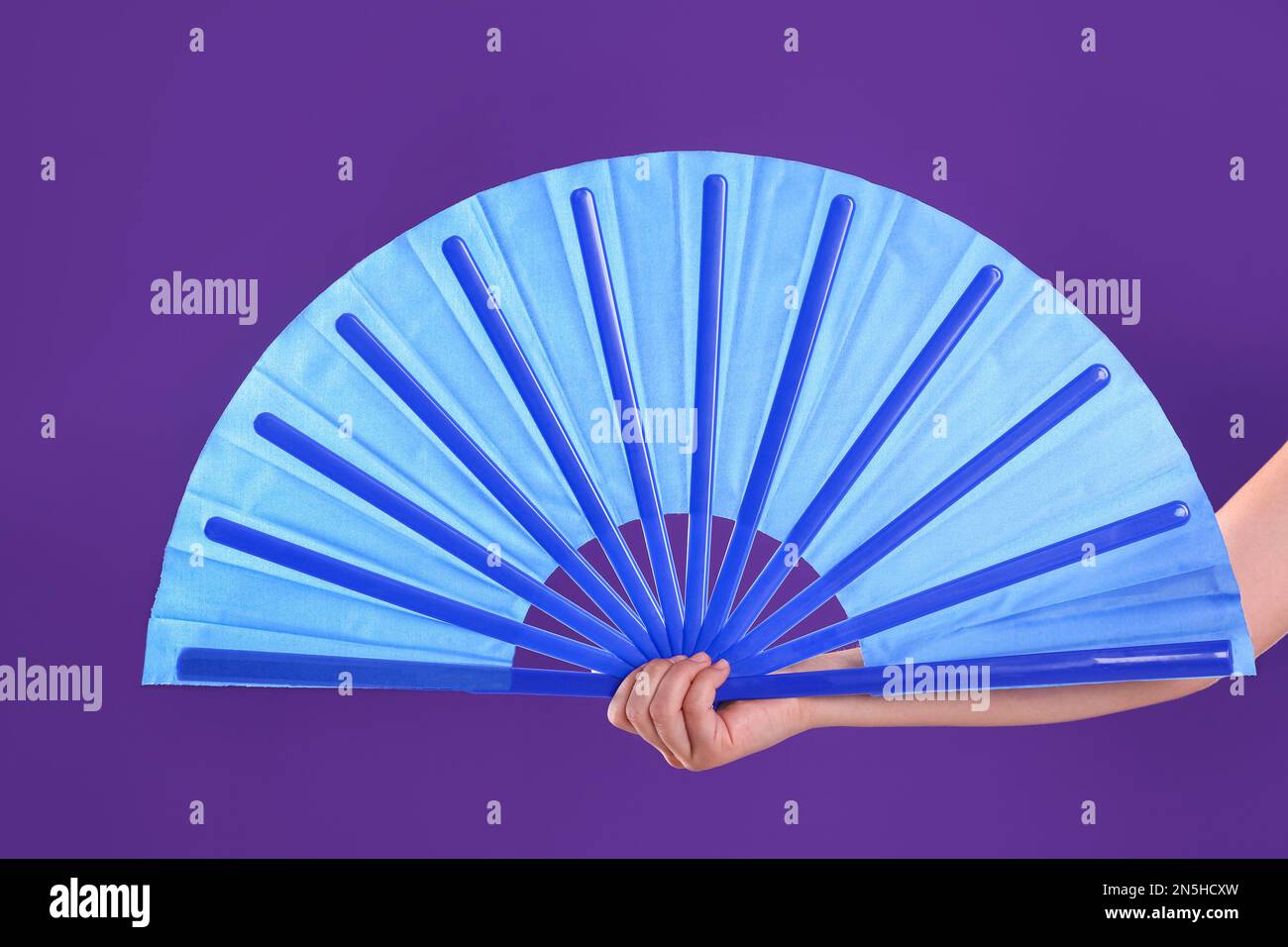 Hand holding blue fan hi-res stock photography and images - Alamy