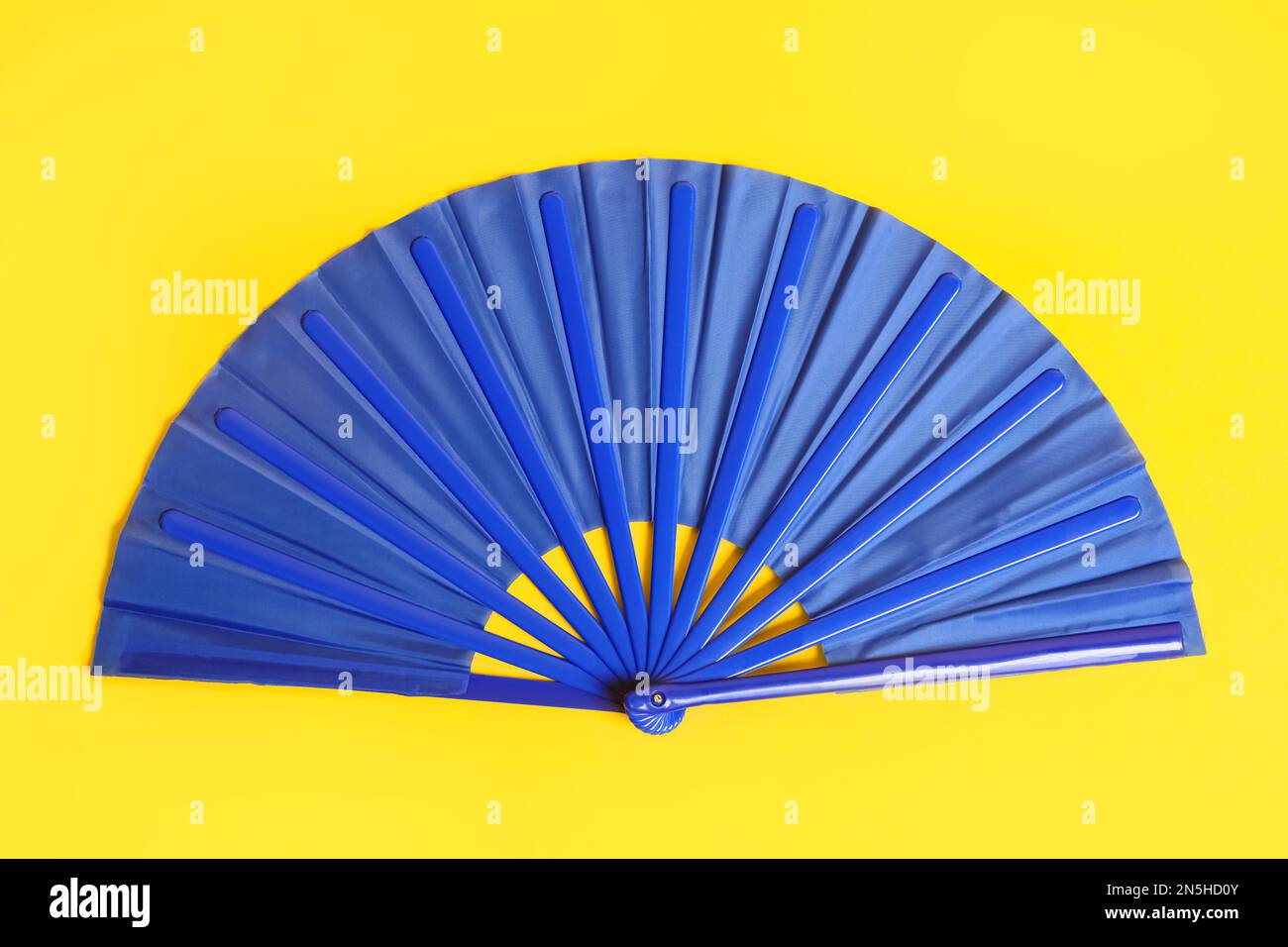 Blue hand fan on yellow background, top view Stock Photo - Alamy