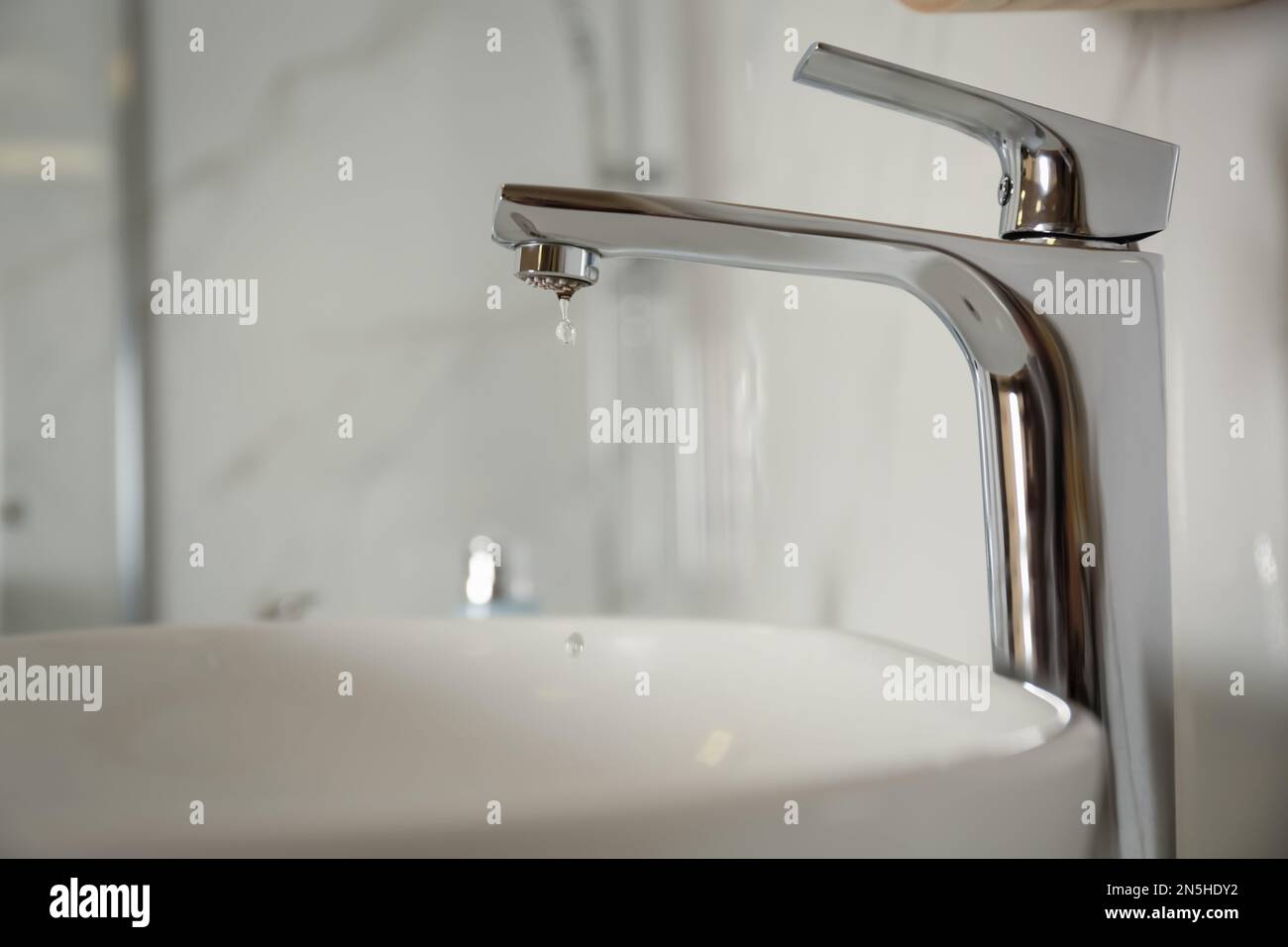 Water drop falling down from tap on blurred background, closeup Stock ...