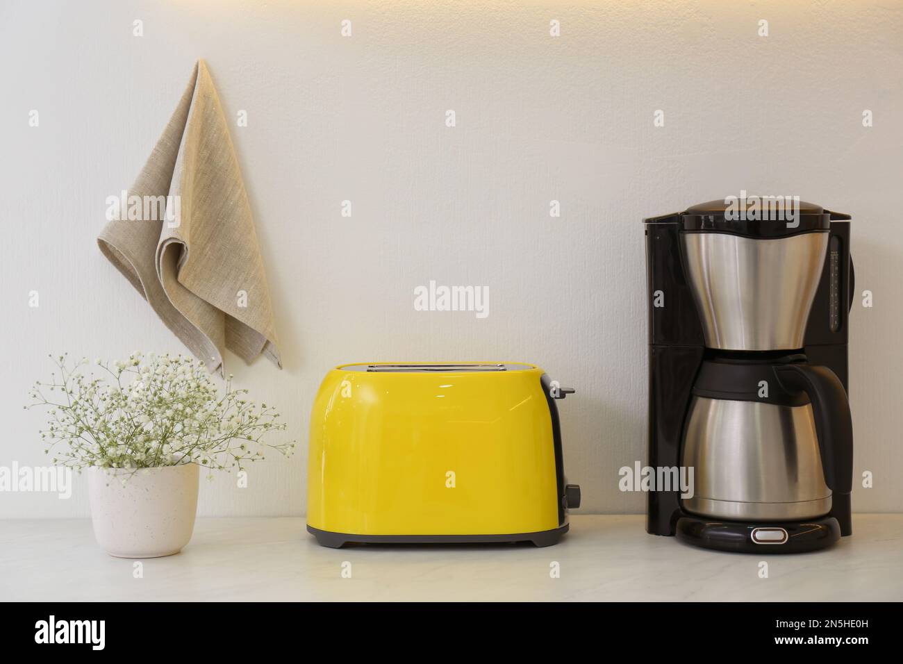 Modern toaster, coffee machine and flowers on counter in kitchen Stock Photo - Alamy