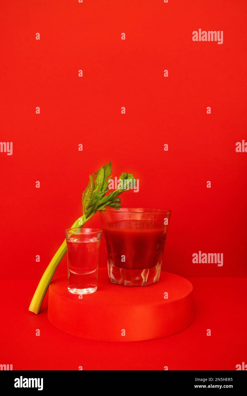 A glass of red cocktail with greens on the podium. Stylish alcohol ...