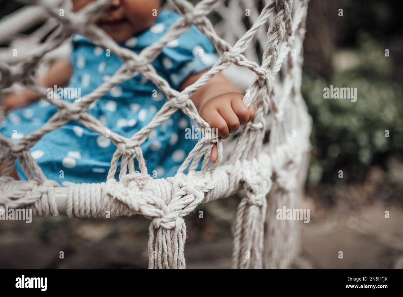 Swarthy little girl in blue polka dot dress has positive emotion ...
