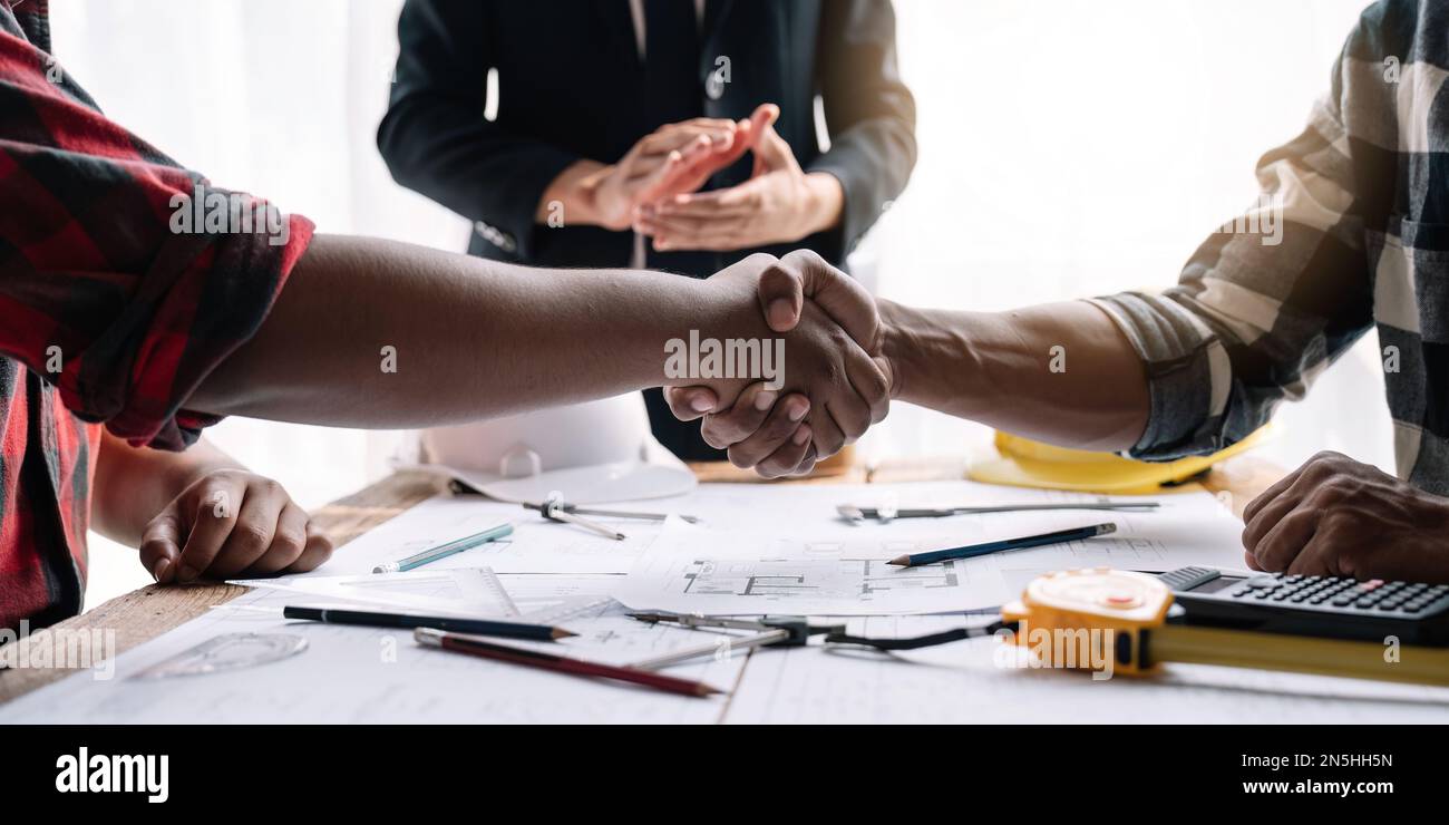 Shaking hands, Blueprints architects and building engineers talking ...