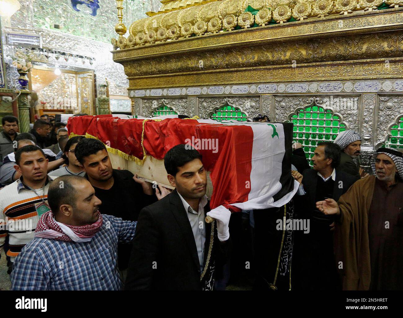 In this photo taken Tuesday, Jan. 21, 2014, Mourners carry the coffin ...
