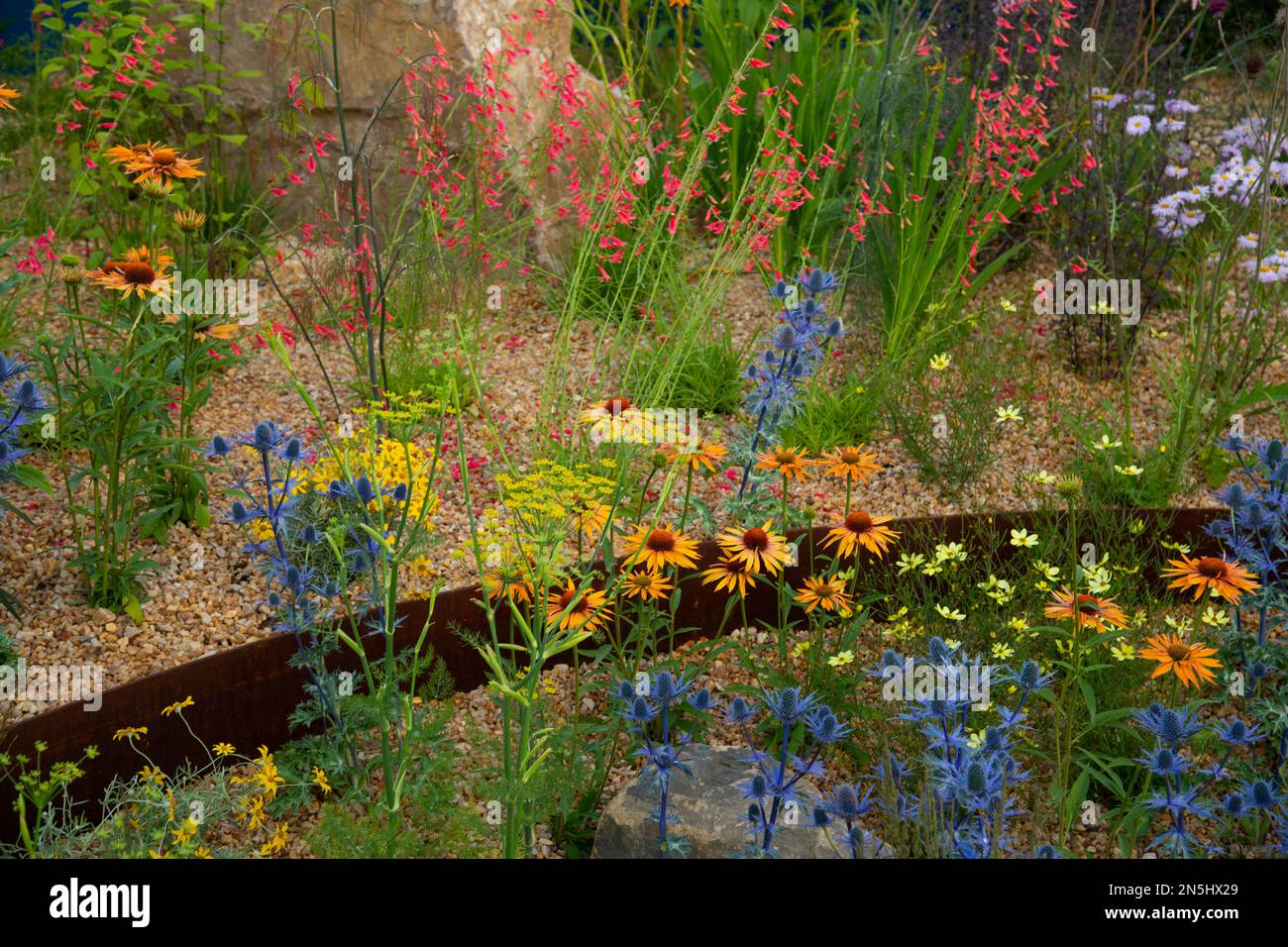 Circular corten steel and gravel around colourful perennials in the ...