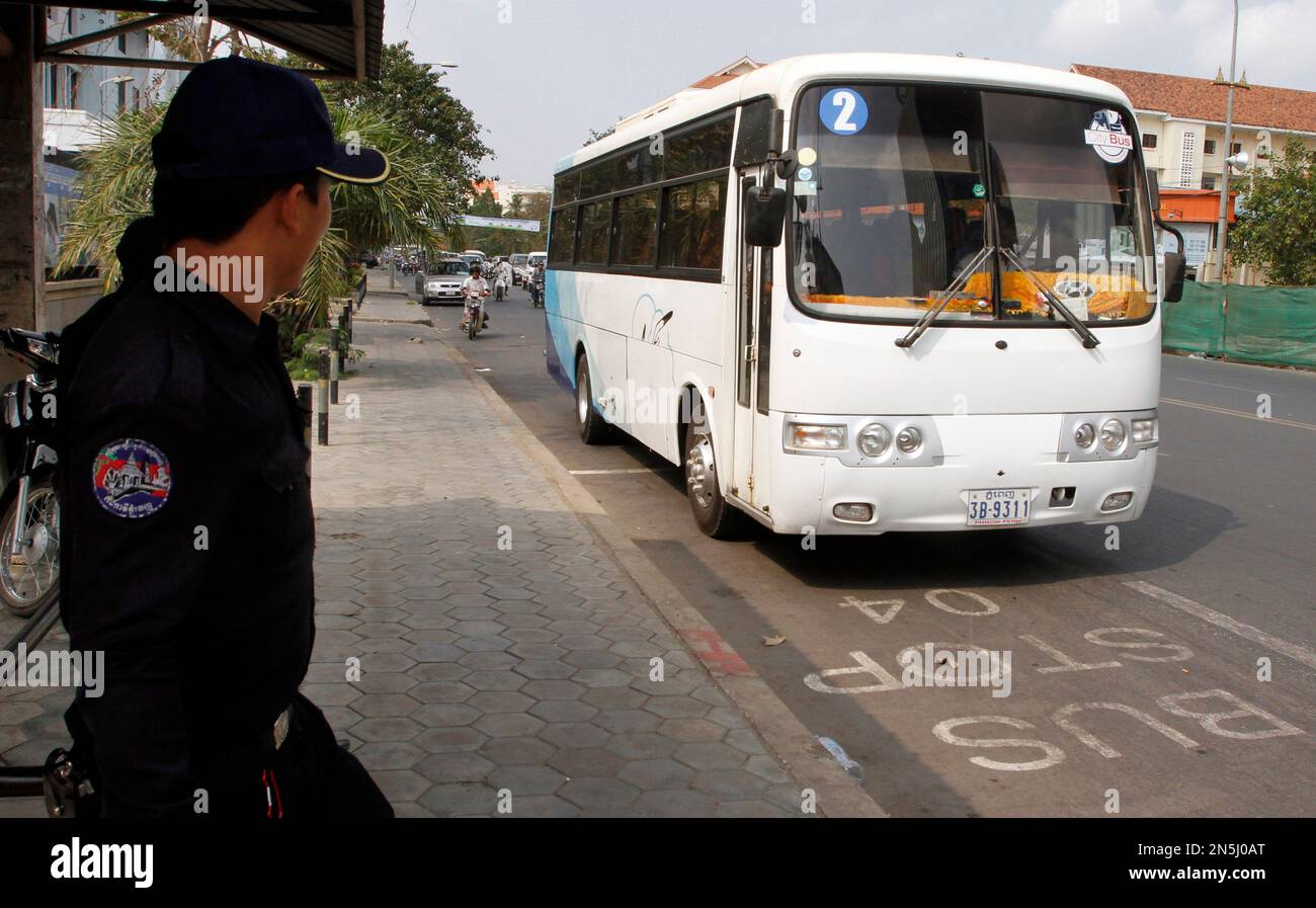 A Security guard stands at a bus stop as Phnom Penh begins its trial ...