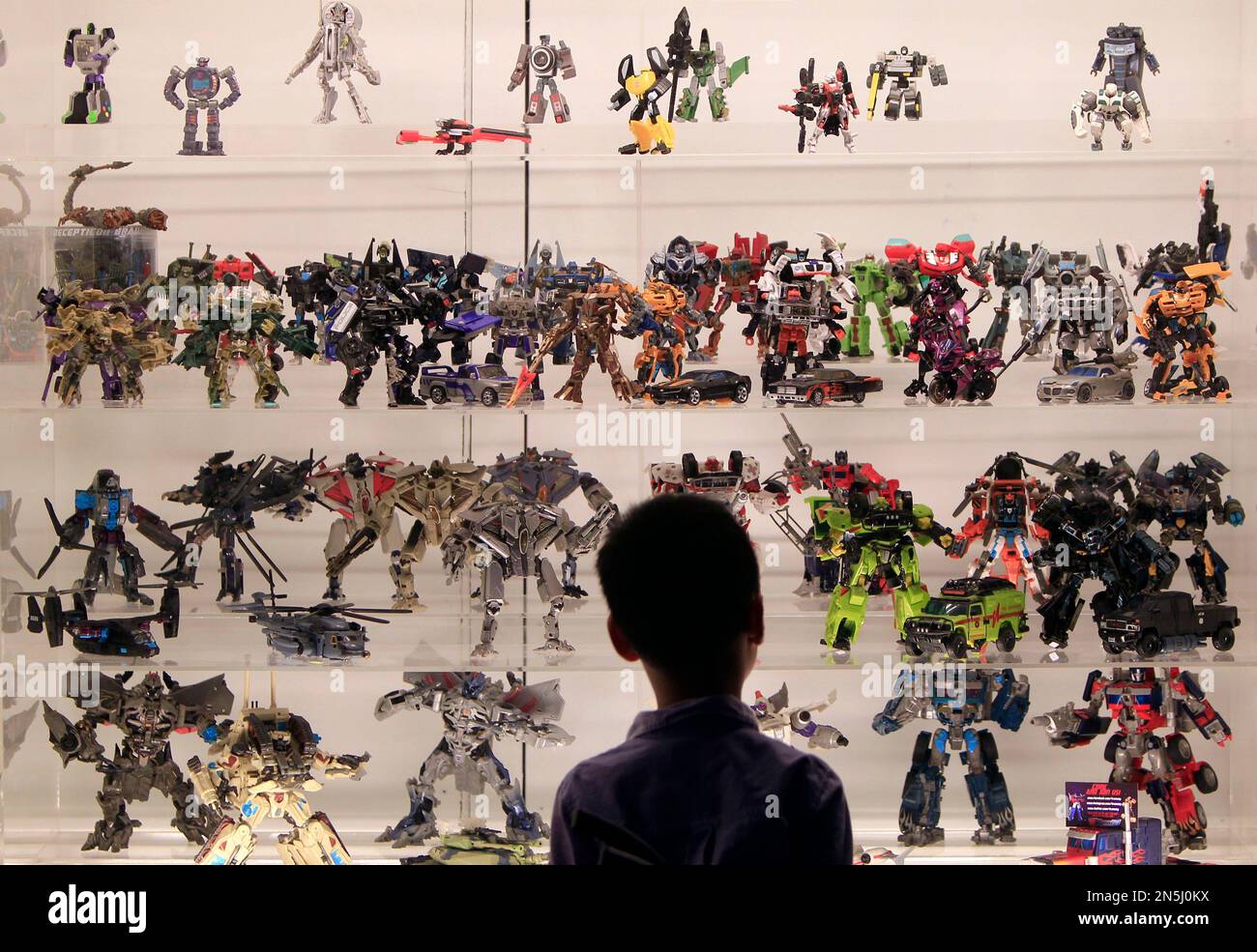A boy looks at models of autobots from the movie "Transformers," at the ...