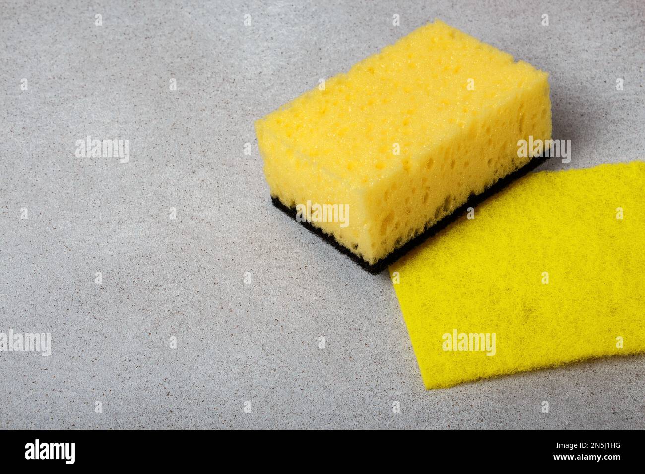 tipes of yellow dishwashing sponge and napkin on grey background. The ...