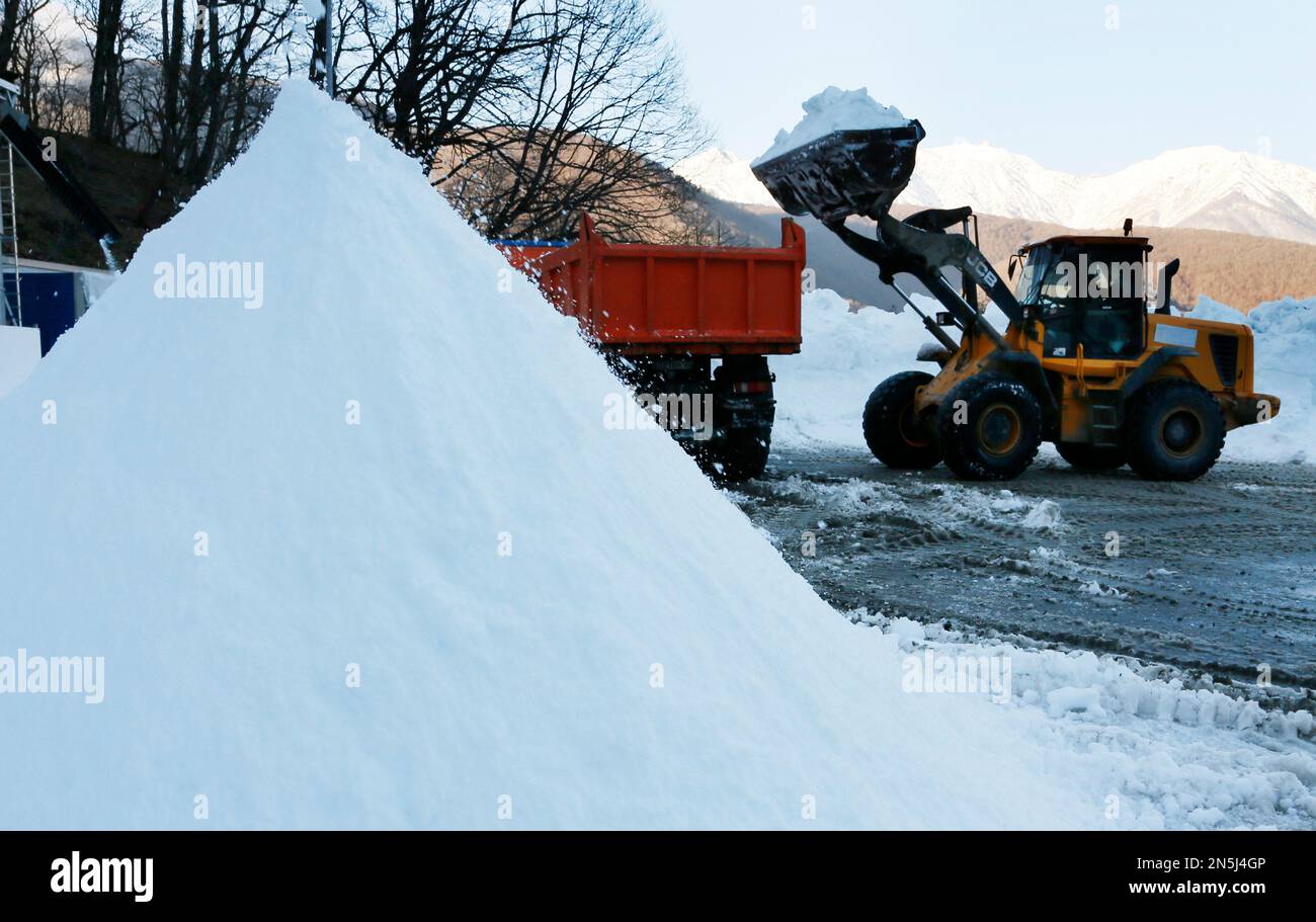 A wheel loader transports artificial snow to prepare the cross country ...