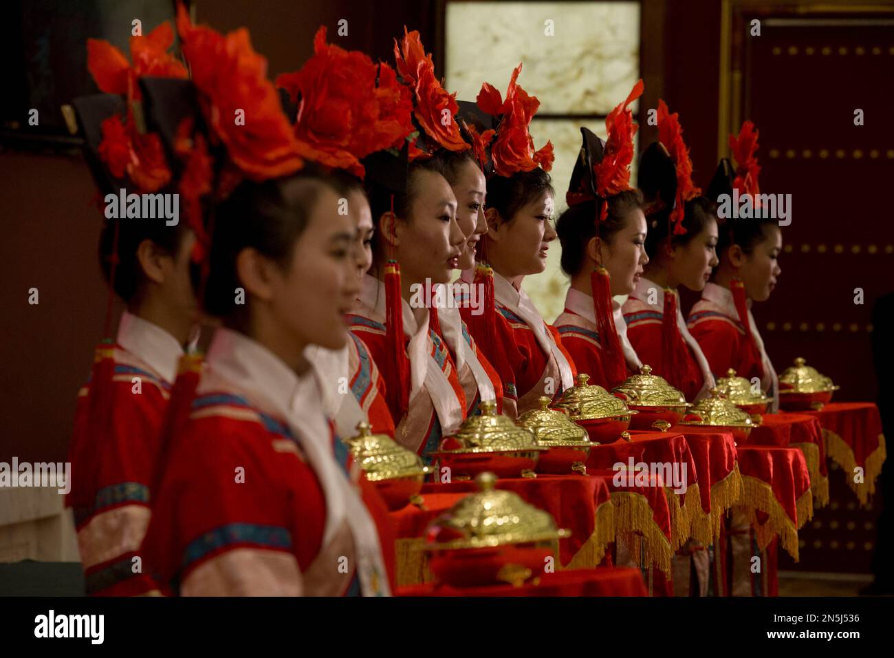 Waitresses dressed in traditional costumes take part in a performance ...