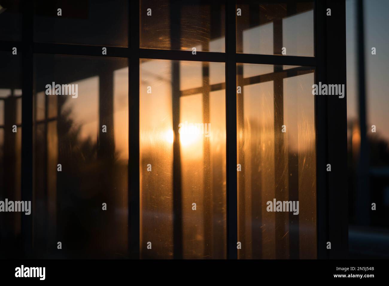 The bright sunset visible through the glass window Stock Photo - Alamy