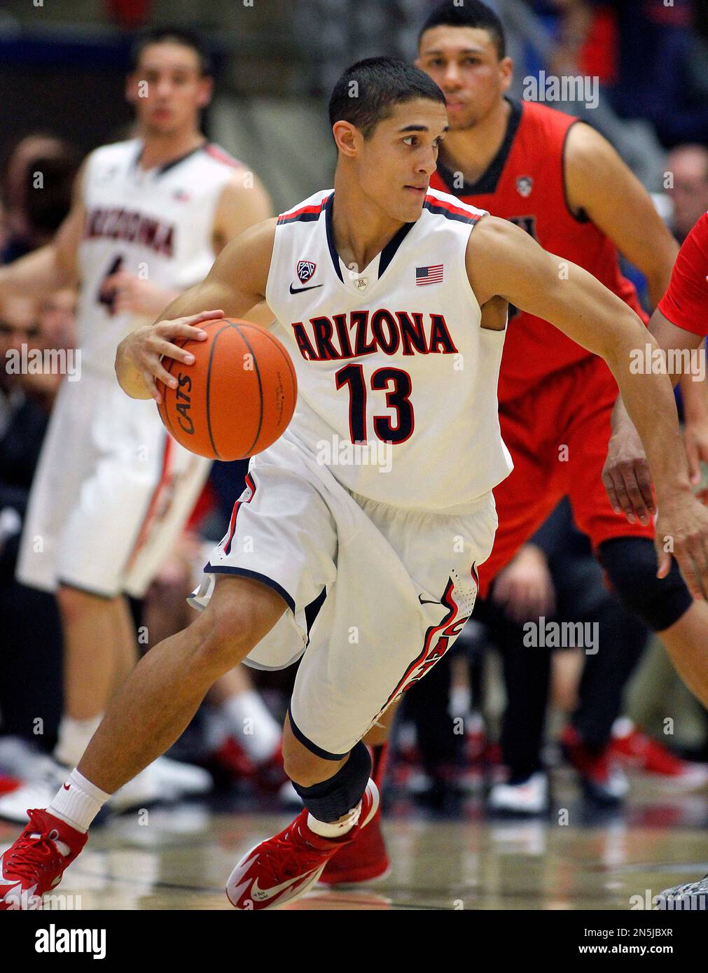 Arizona's Nick Johnson (13) dribbles the ball in front of Utah's Jordan ...
