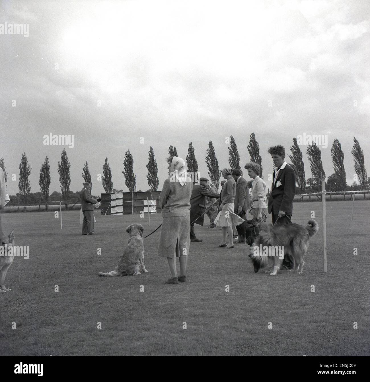 1963, historical, outside in a large field, several owners standing in ...