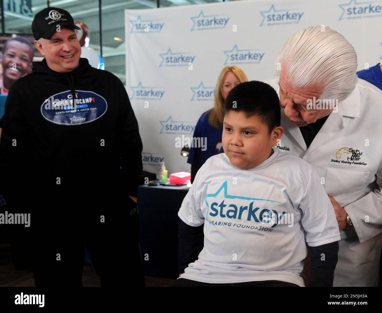 Garth Brooks, left, looks on as Bill Austin, Founder of Starkey Hearing ...