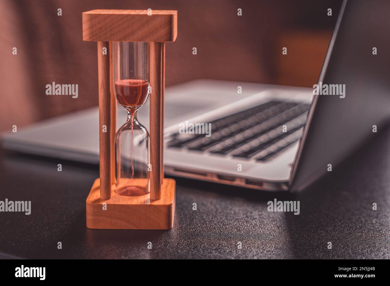 Laptop and hourglass on the desktop. Time management concept Stock ...