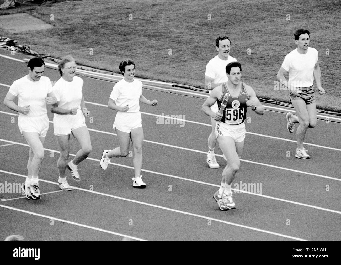 Scottish athlete Allan Wells holds the baton which contains the message ...
