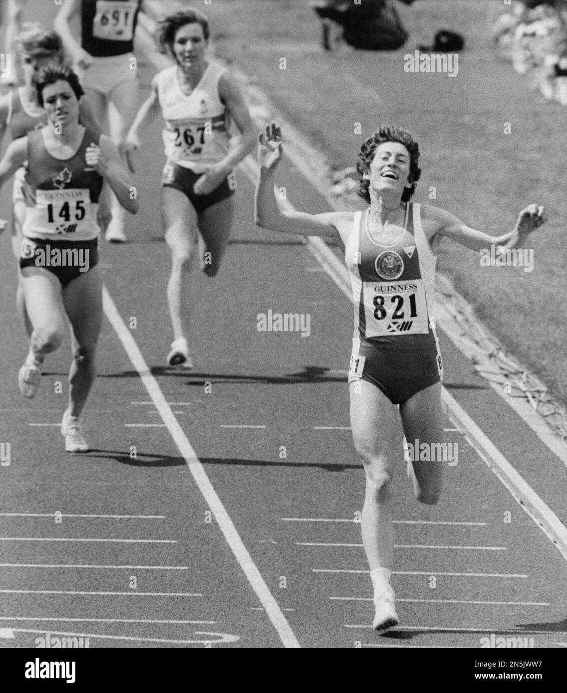 Kirsty Wade of Wales, raises her arms as she crosses the finish line to ...