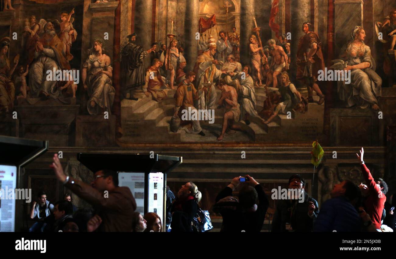 Crowds look up at frescos by Italian artist Raphael and his followers ...