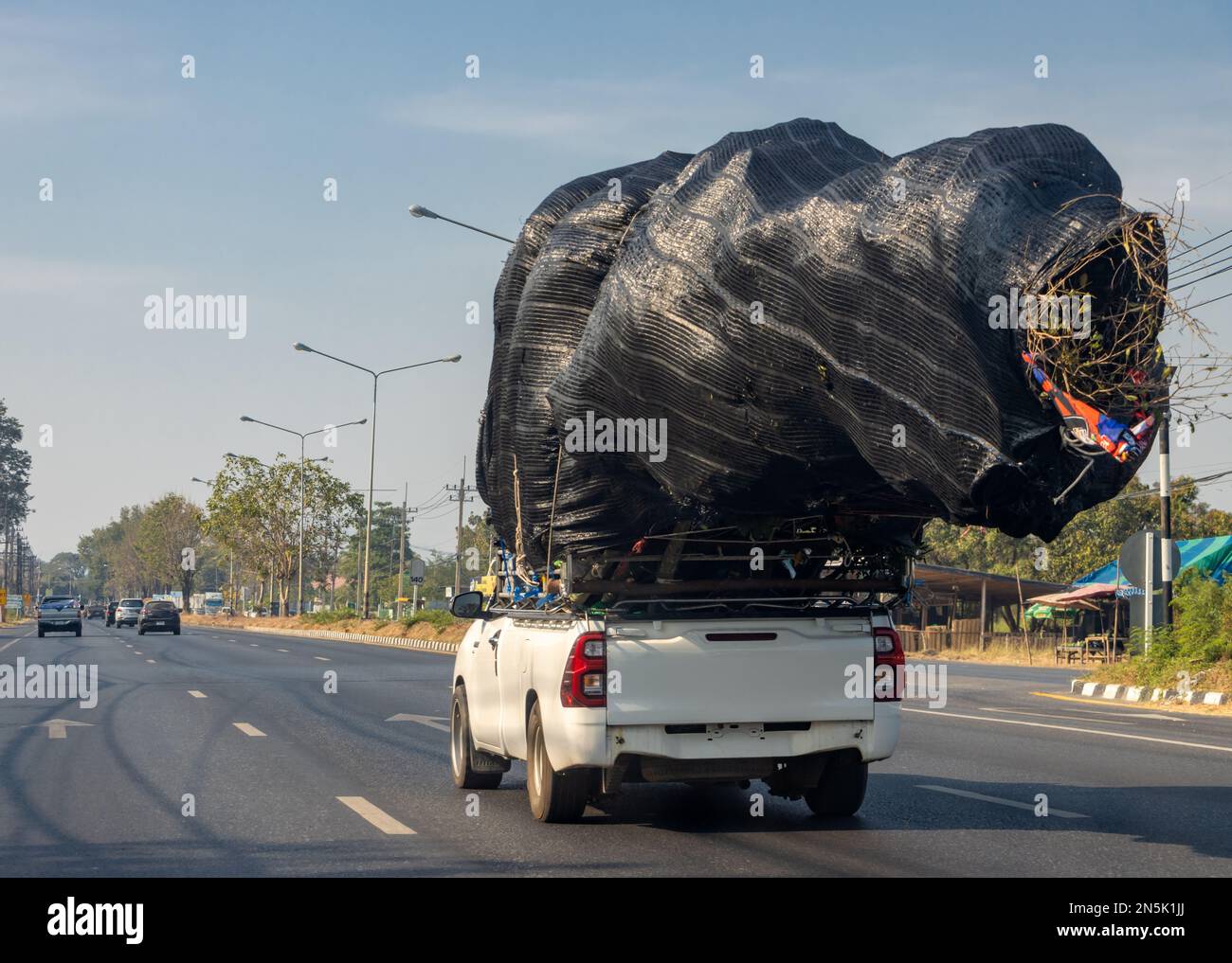 A pickup truck is driving on the highway with an excessive load - a ...