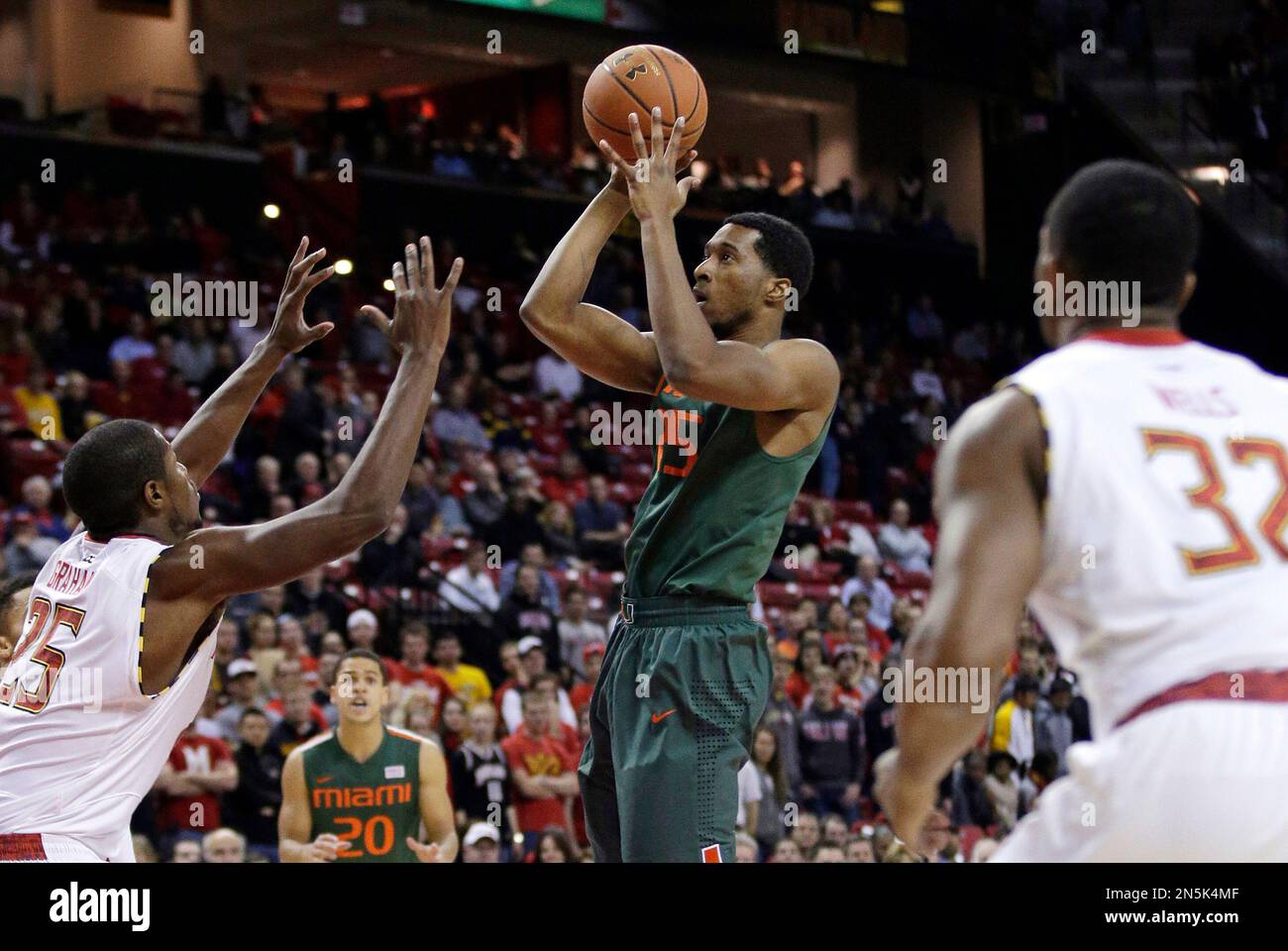 Miami guard Garrius Adams, center, shoots over Maryland forward ...