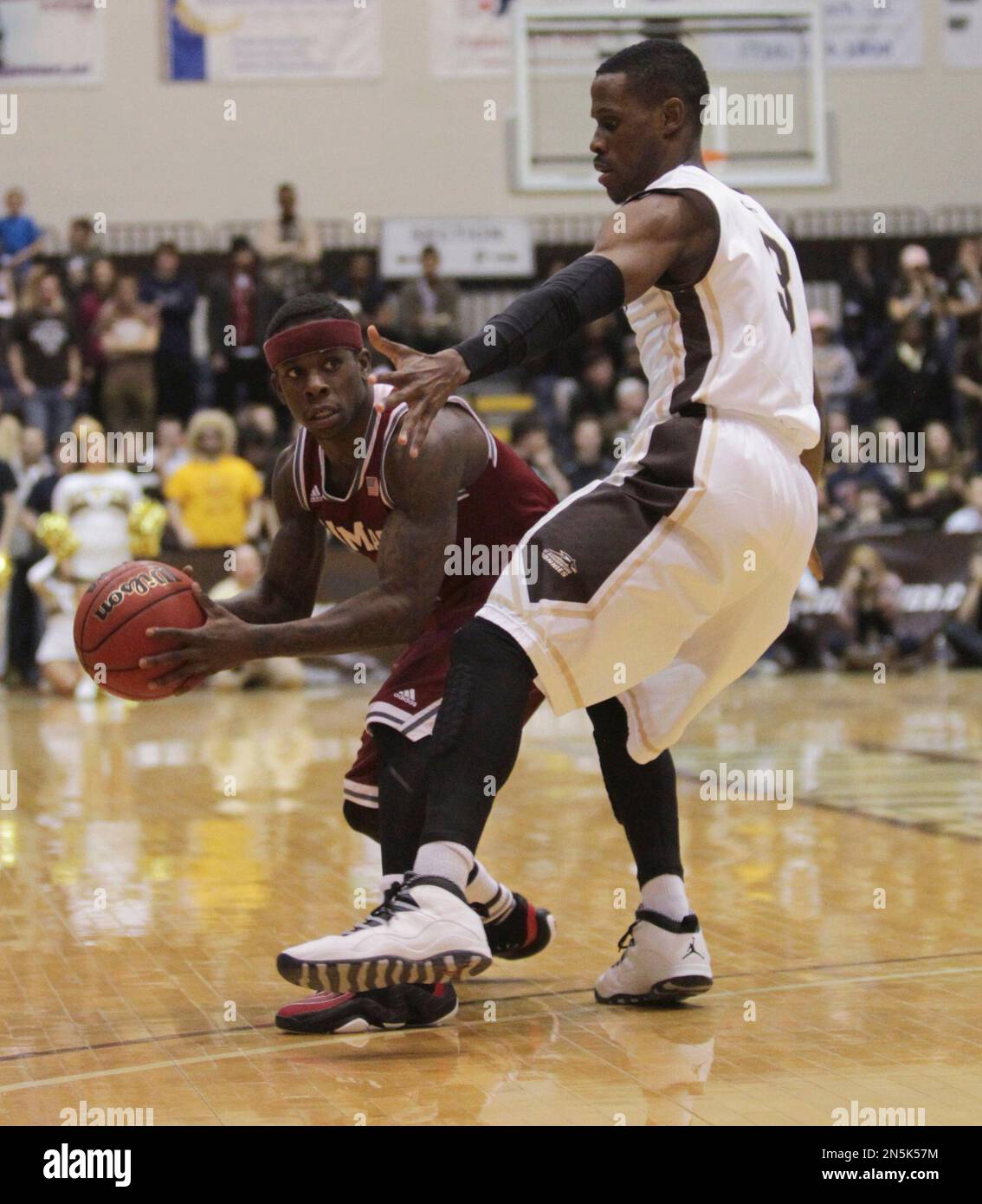 Massachusetts guard Chaz Williams, left, looks to pass around St ...
