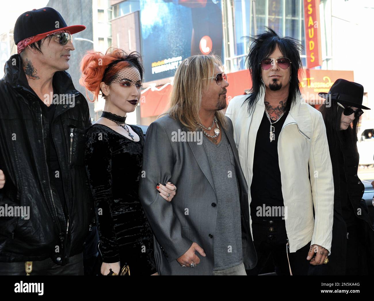 From left, Motley Crue band members, Tommy Lee, an unidentified woman ...