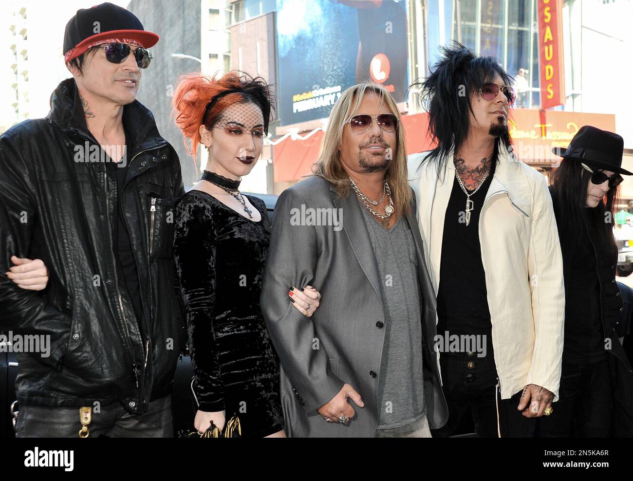From left, Motley Crue band members, Tommy Lee, an unidentified woman ...