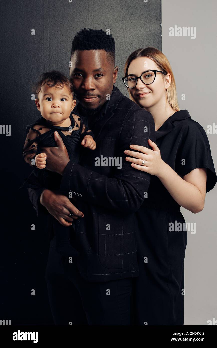 Happy interracial family with baby daughter poses in studio. Concept of ...