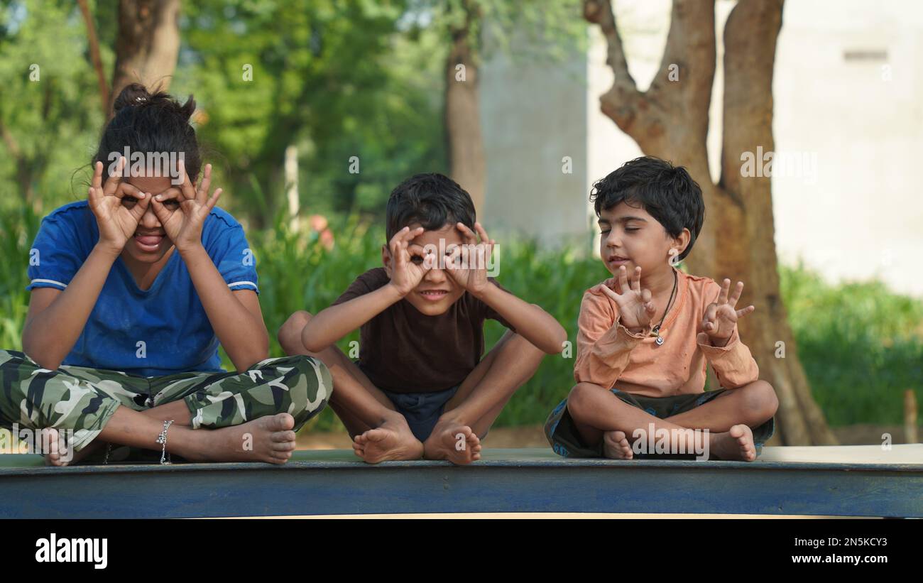 Two Indian little girl and a boy doing meditate yoga asana on roll mat ...