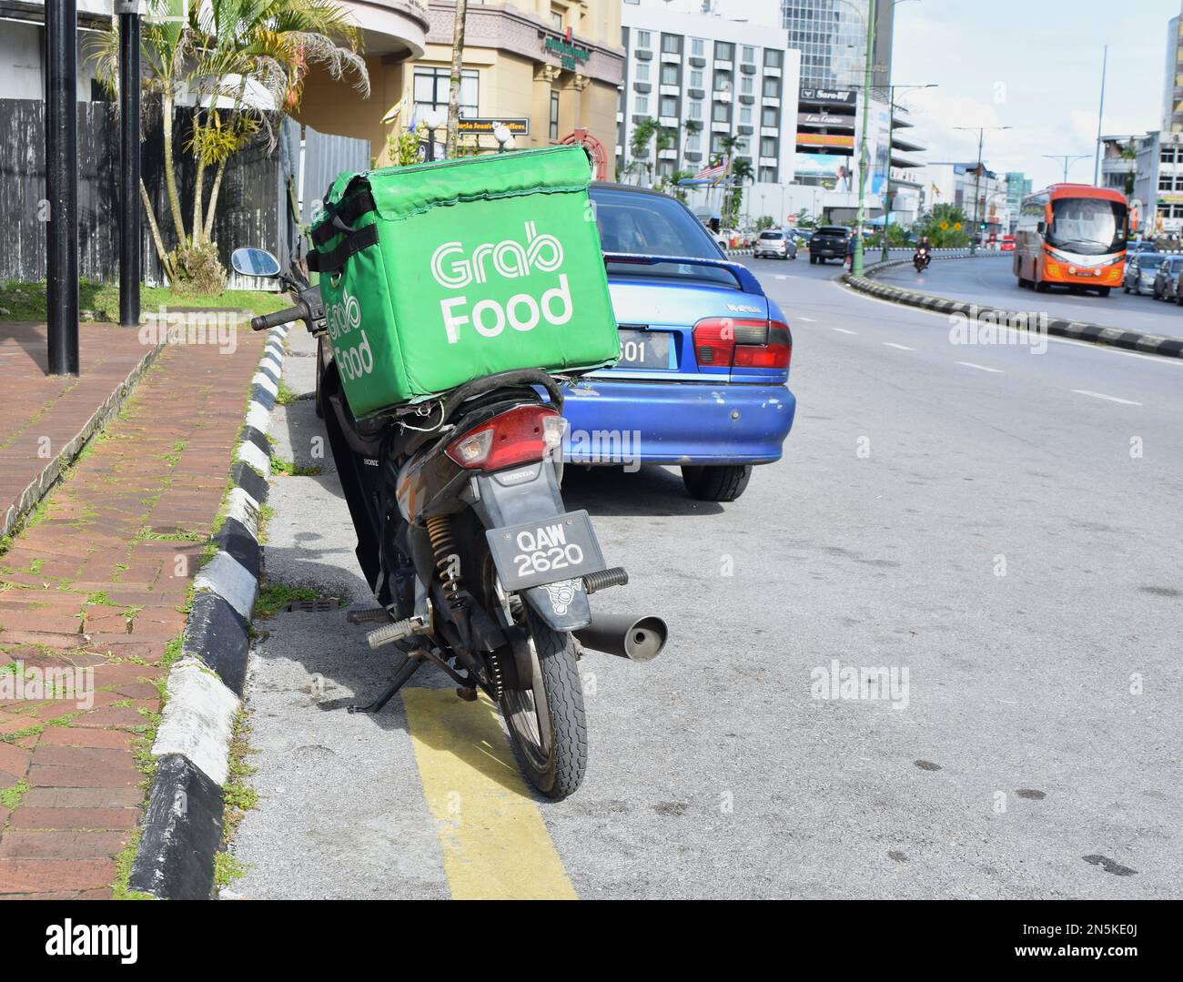 Grab food delivery bike parked on Kuching city road Stock Photo - Alamy