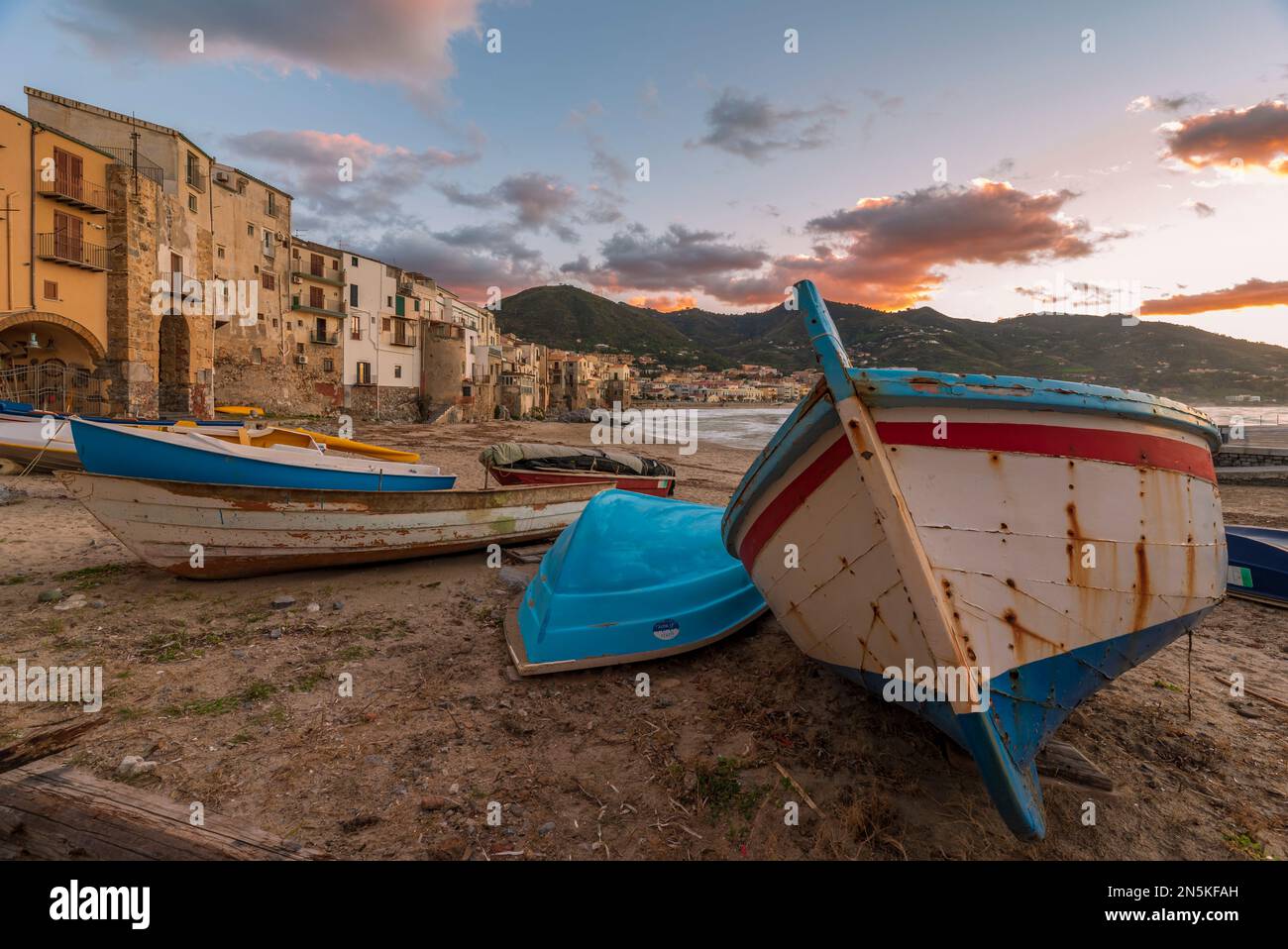 Sunset over the fishing boats in Cefalù beach, Sicily Stock Photo - Alamy