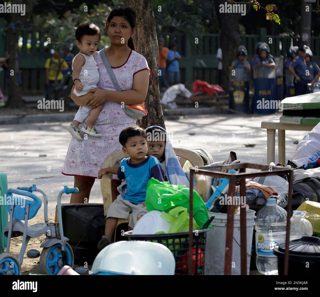 A mother and her children look at their shanty being demolished by ...
