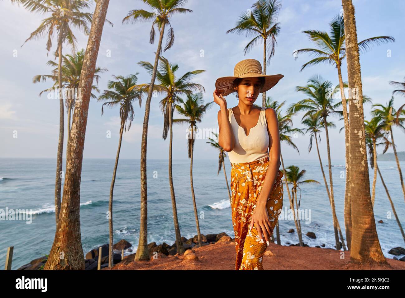 Young african female model posing in colorful clothes at tropical ...