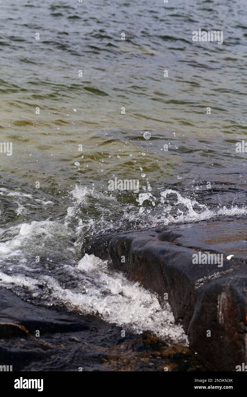 Lots of small waves hitting red and black beach rocks in Eira aka ...