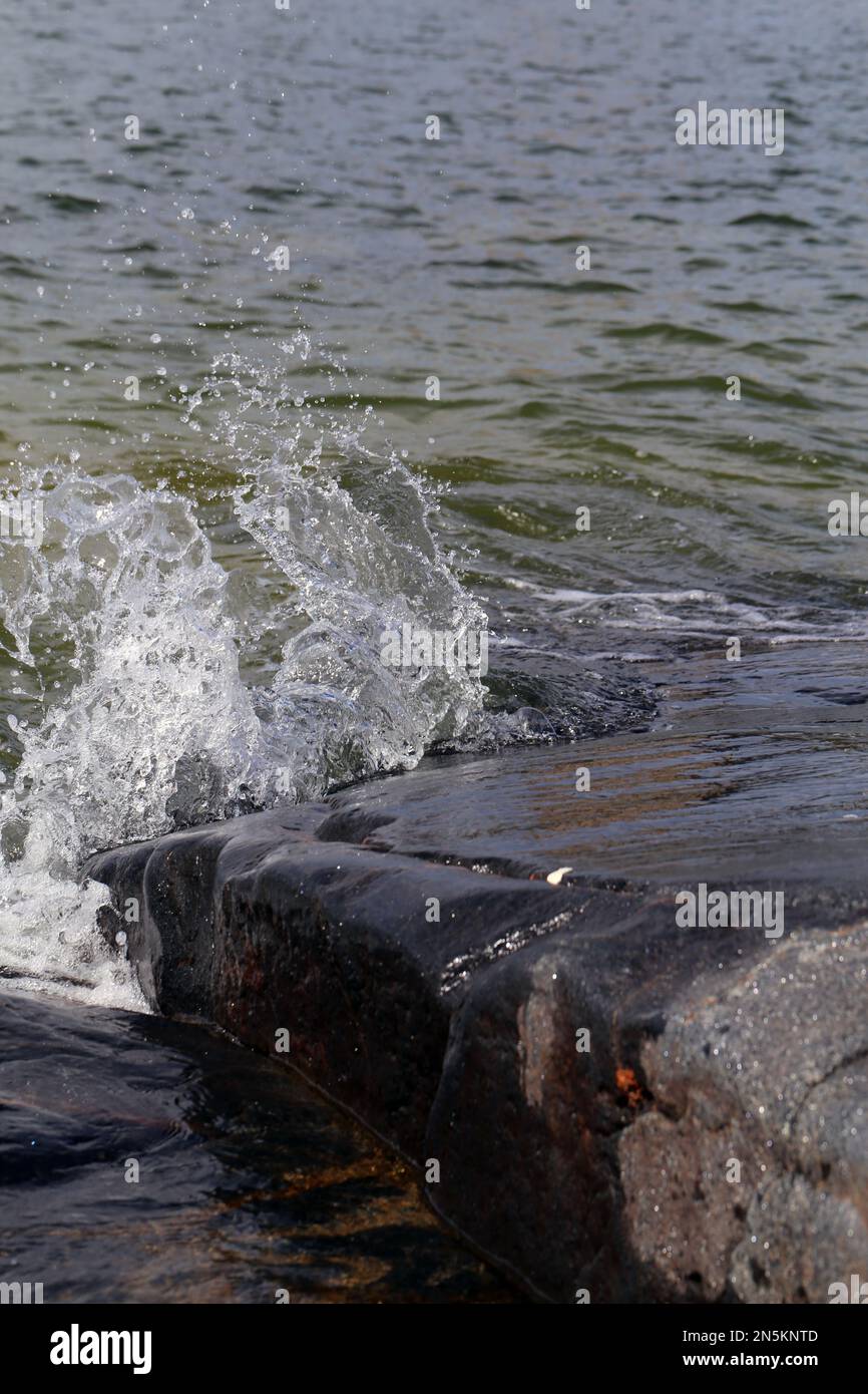 Lots of small waves hitting red and black beach rocks in Eira aka ...