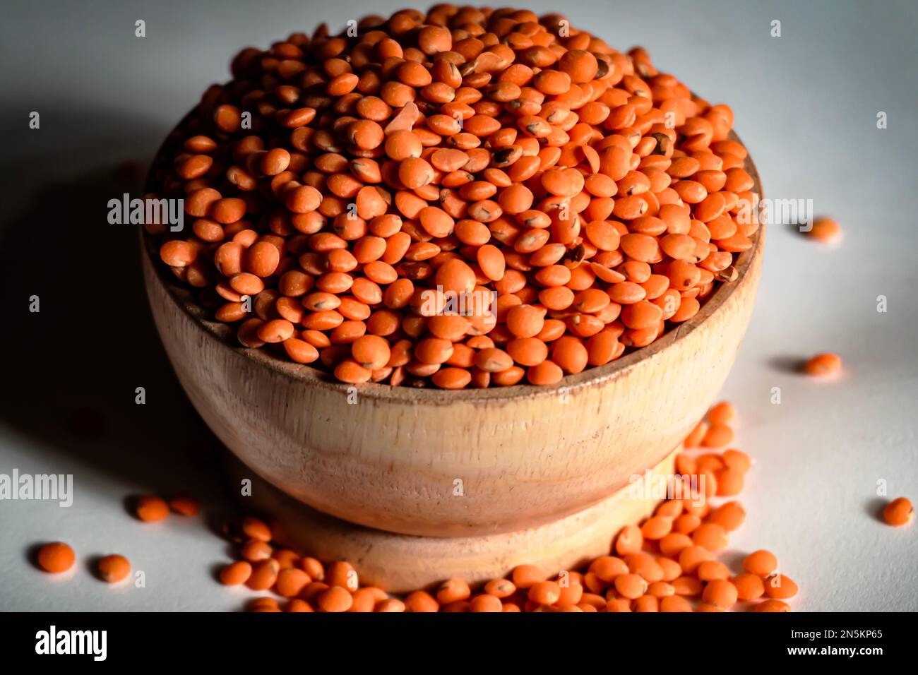 Lentil in a wooden bowl isolated on a white background. Lentil is a ...