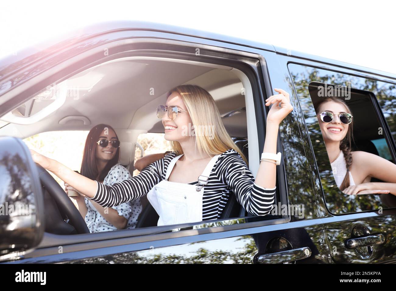 Happy friends together in car on road trip Stock Photo - Alamy