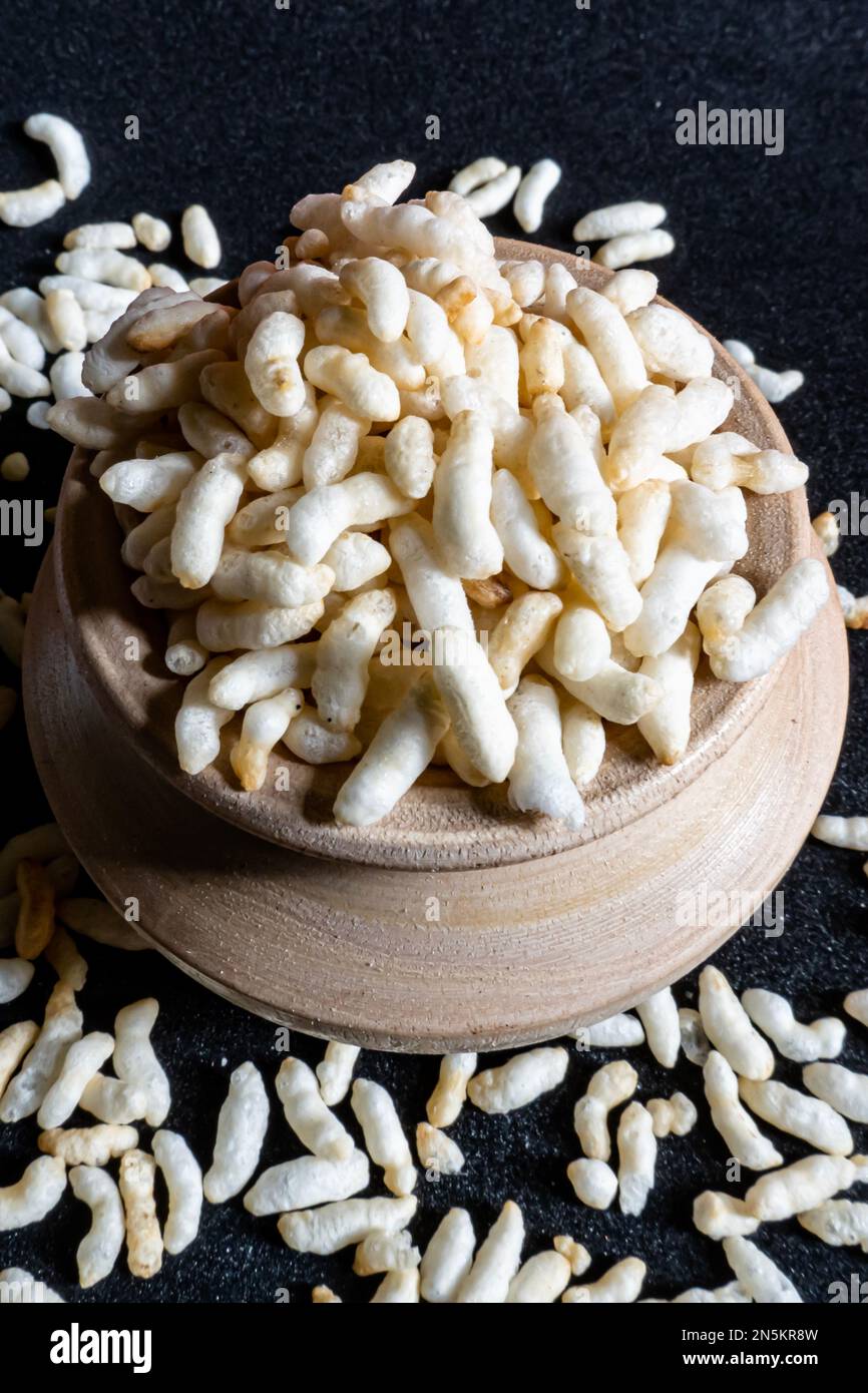 Portrait view of puffed rice in a wooden bowl isolated on black ...