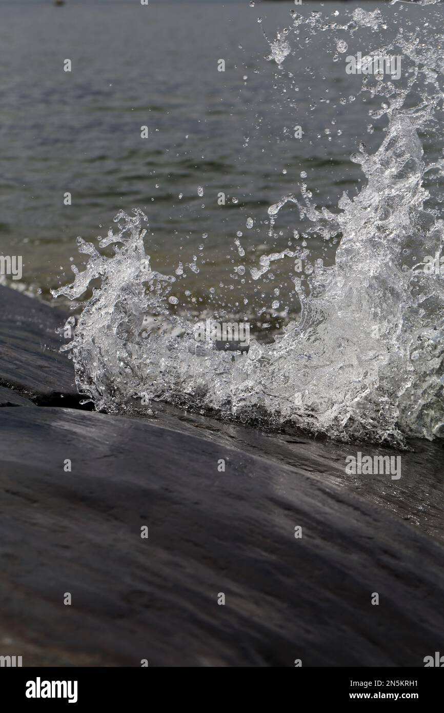 Lots of small waves hitting red and black beach rocks in Eira aka ...