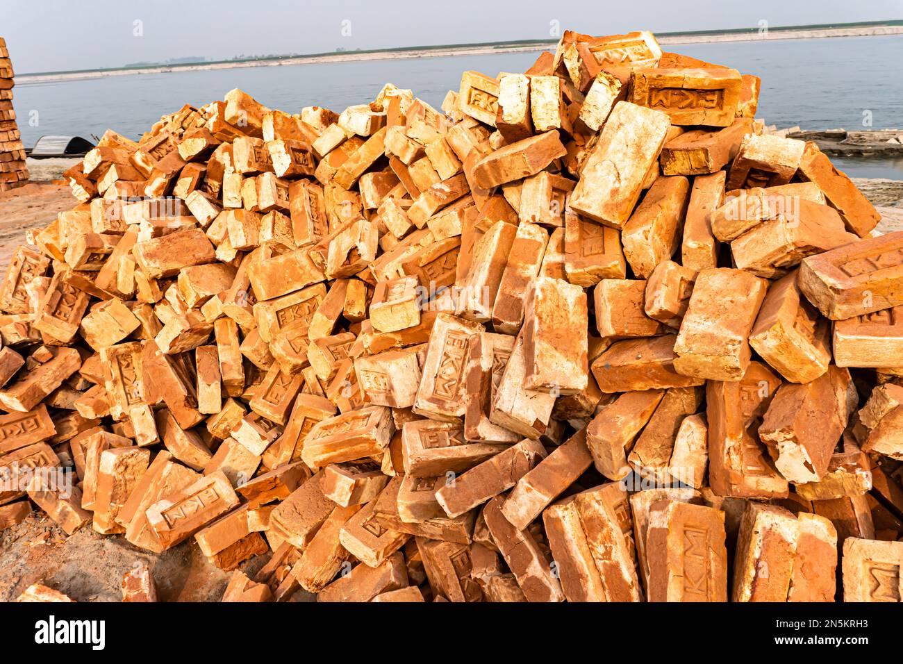 A pile of red bricks isolated beside river background Stock Photo - Alamy
