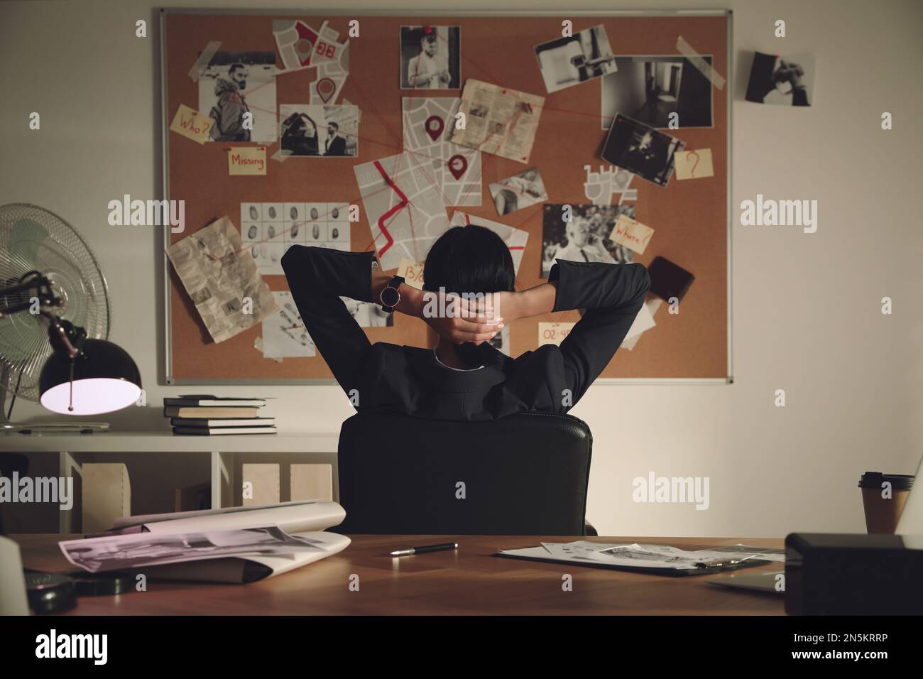 Detective looking at evidence board in office, back view Stock Photo ...