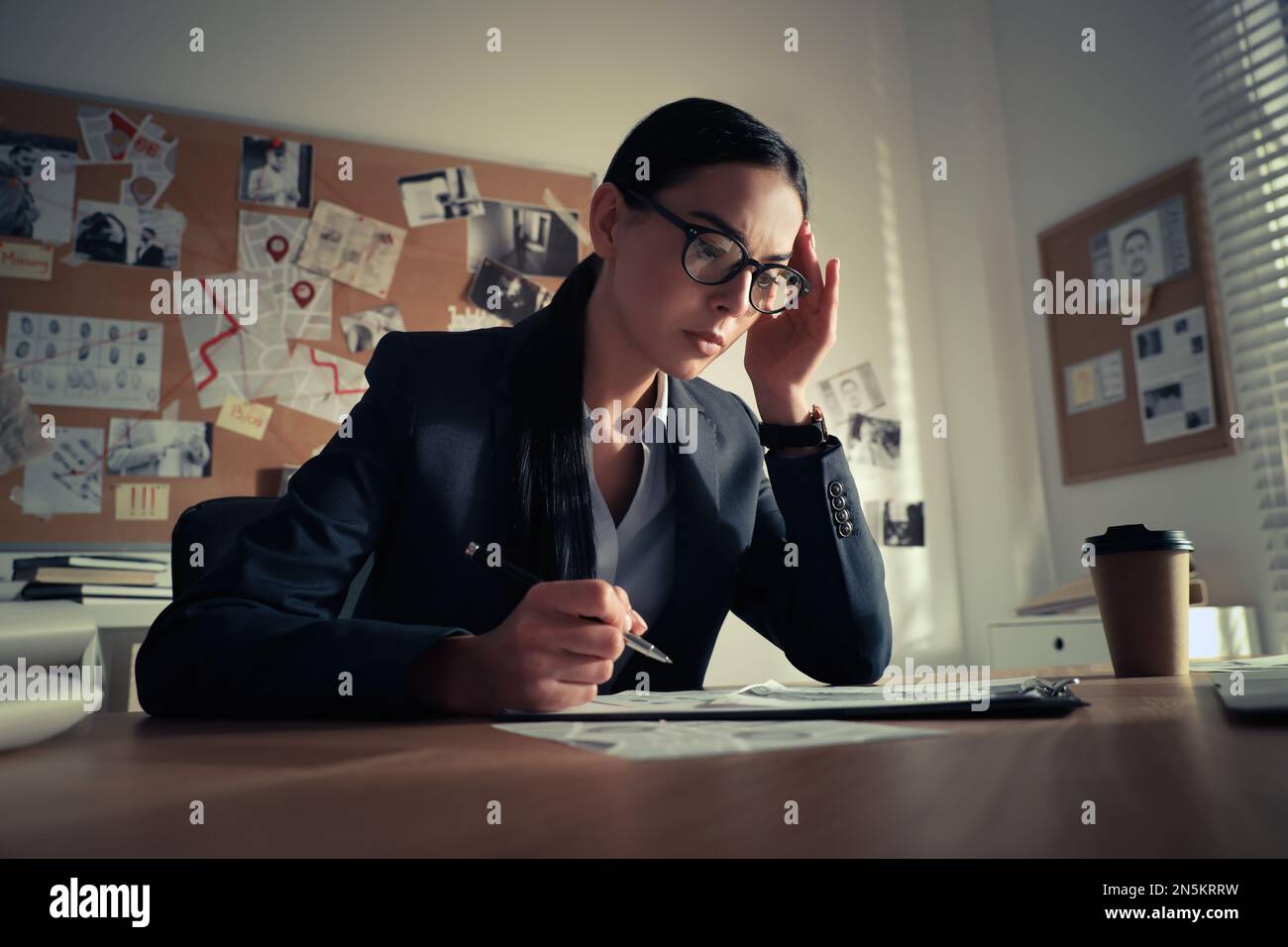 Detective working at desk in her office Stock Photo - Alamy