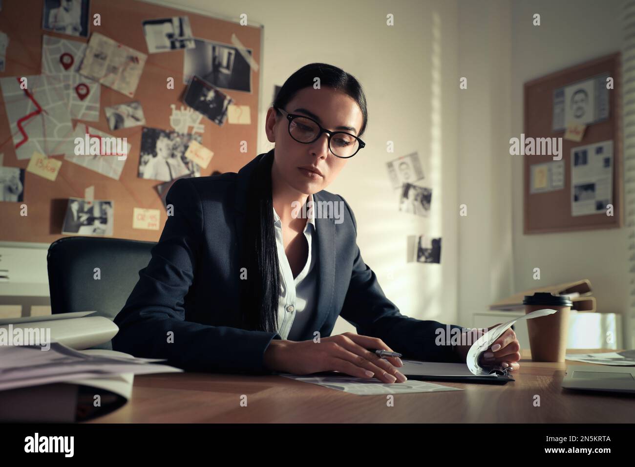 Detective working at desk in her office Stock Photo - Alamy