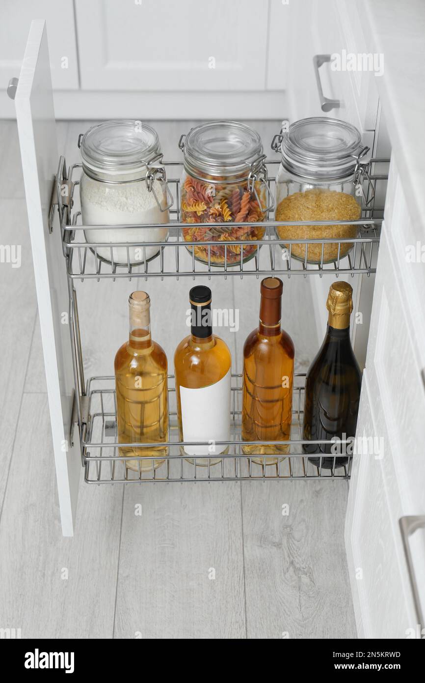 Open drawer with jars of food and wine bottles in kitchen Stock Photo ...